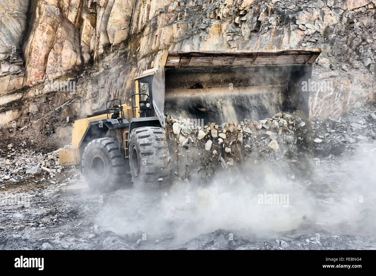 Wheel loader machine unloading rocks in the open-mine of iron ore Stock ...
