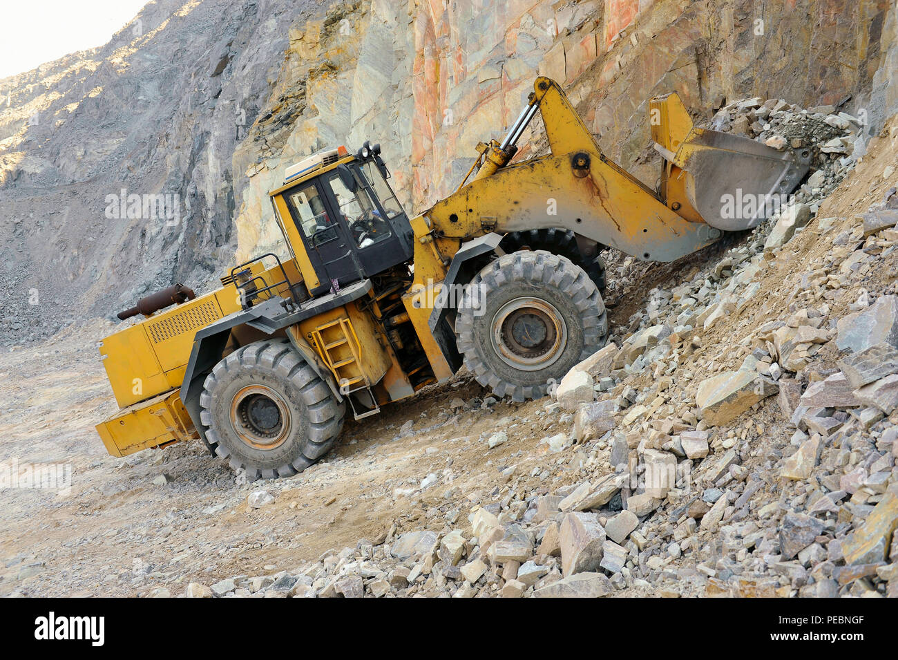 Wheel loader machine unloading rocks in the open-mine of iron ore Stock ...