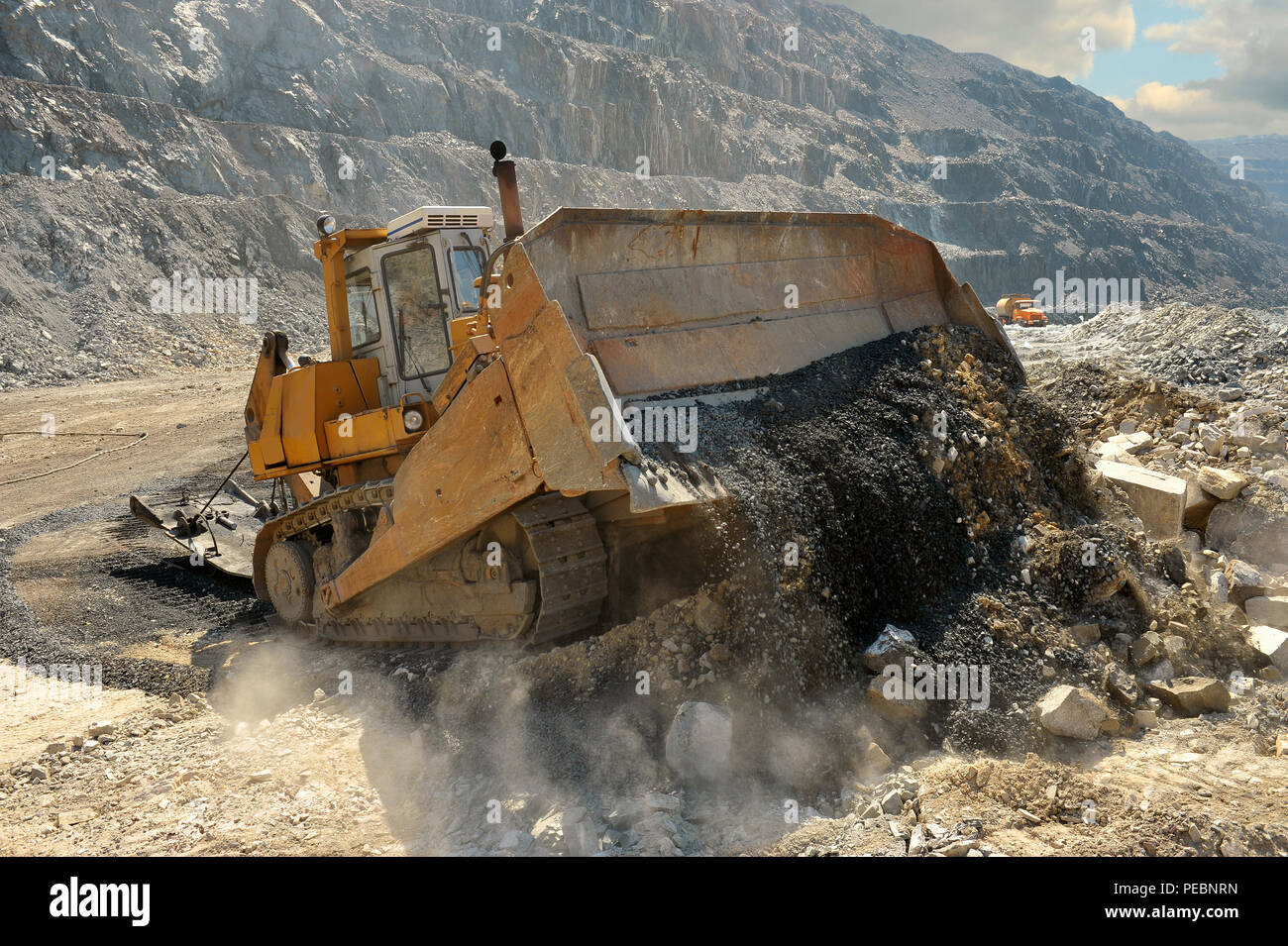 Wheel loader machine unloading rocks in the open-mine of iron ore Stock ...