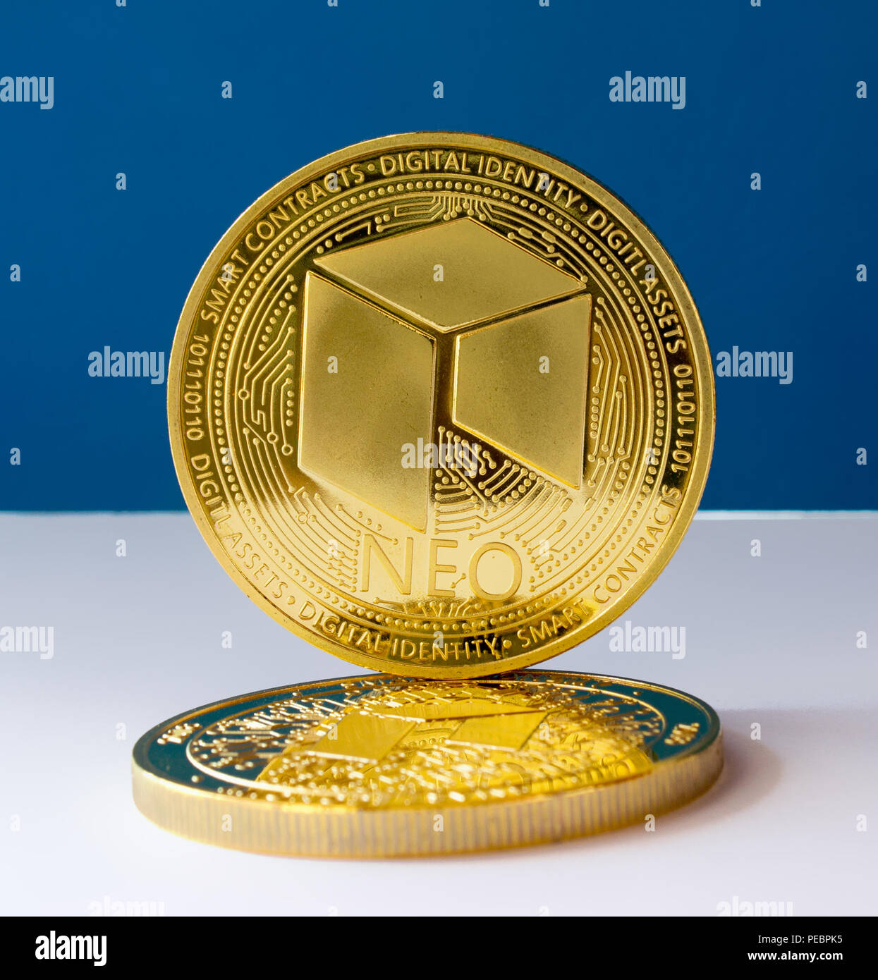 On a blue background are coins of a digital crypto currencies - neo. In ...