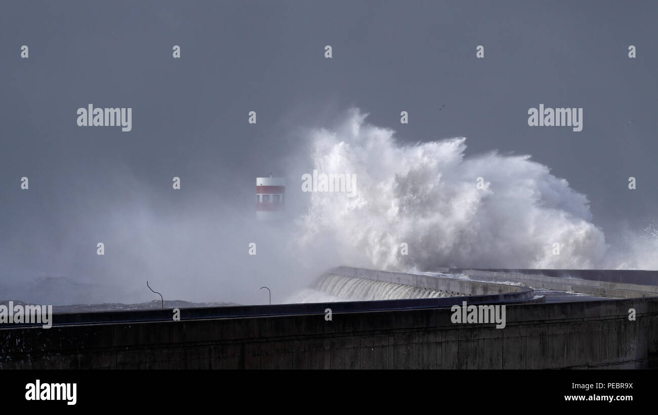 Big windy white wave over beacon and pier Stock Photo - Alamy