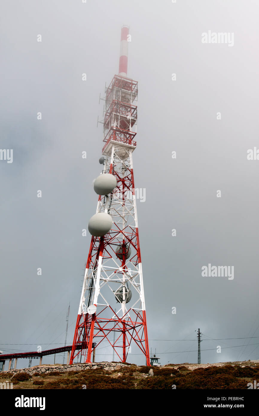 Red and white communication tower with antennas in the top of a ...