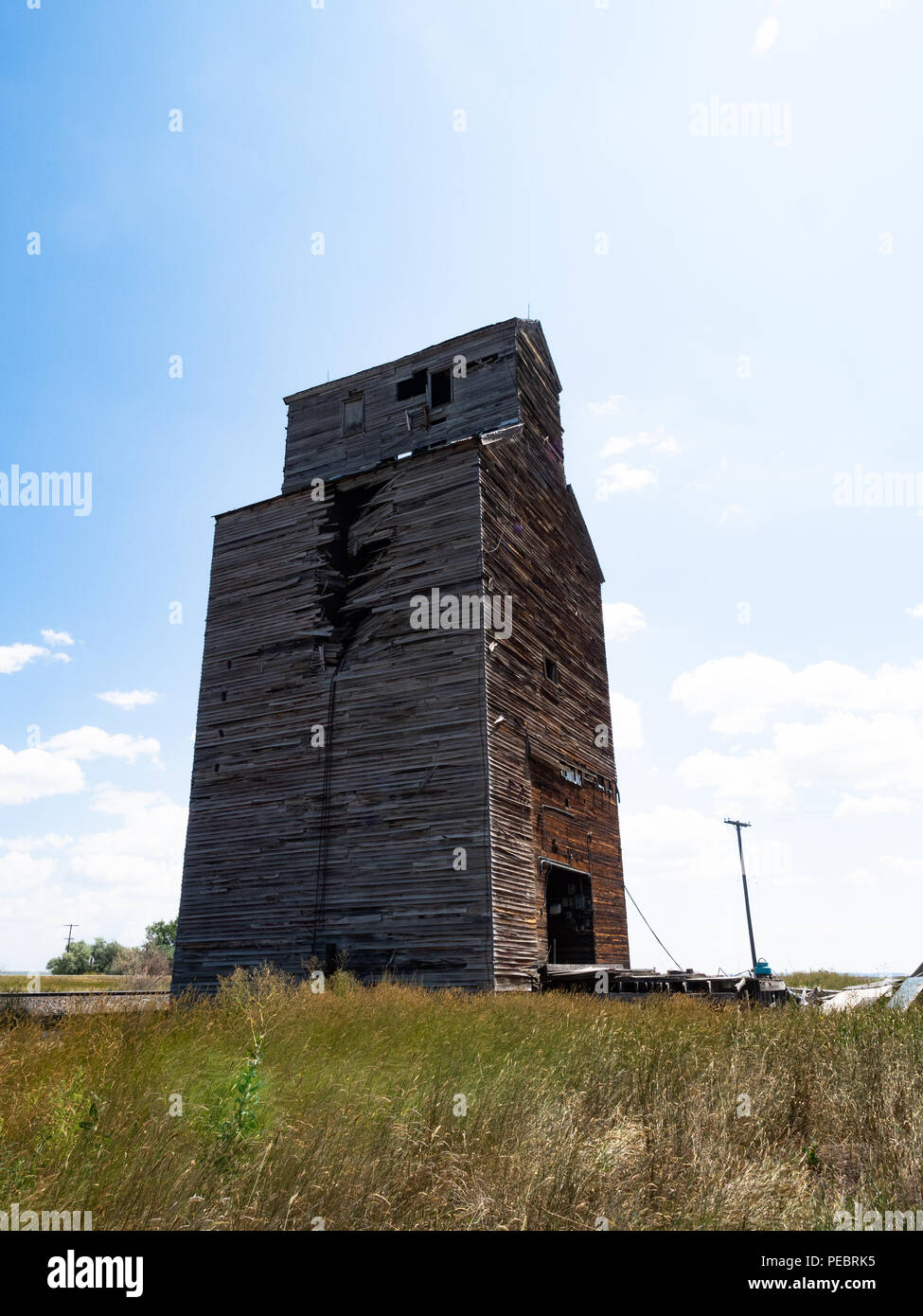 An old, rundown, damaged wooden grain elevator in rural Montana ...