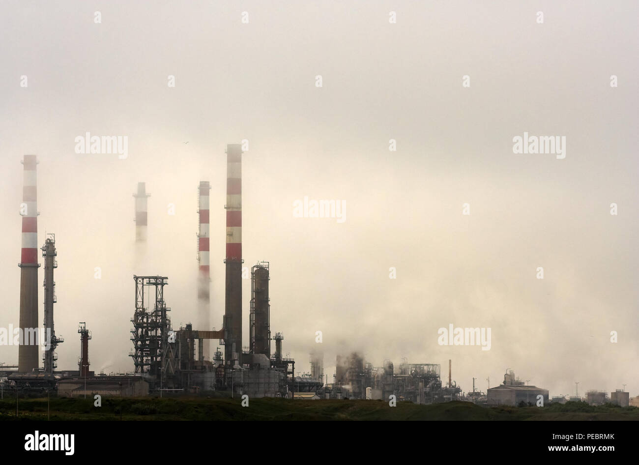 Oil refinery in the middle of fog, clouds and pollution Stock Photo - Alamy