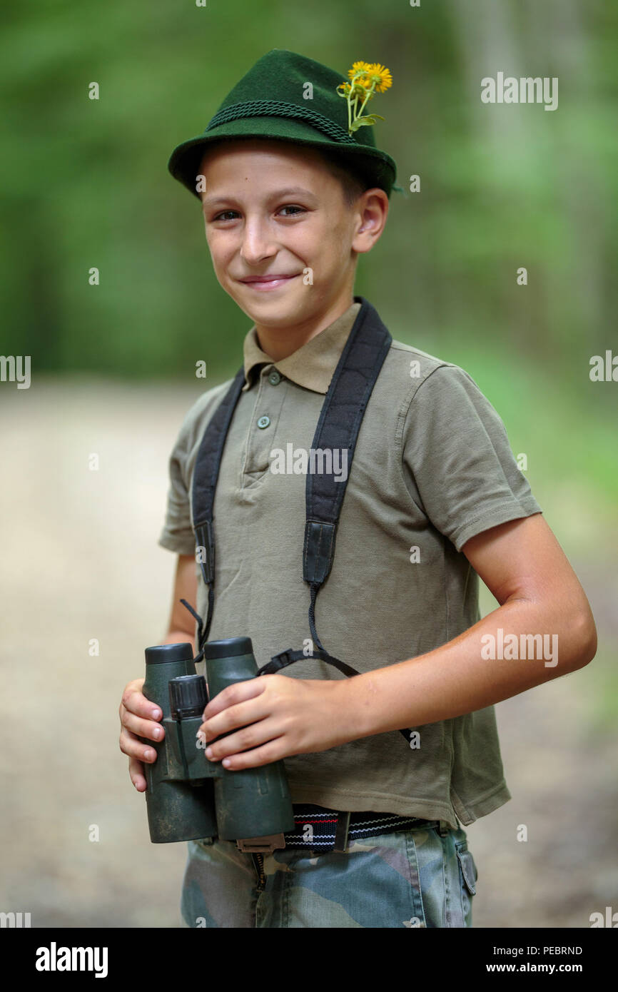 Closeup of a young boy dressed as a hunter with binoculars in the ...