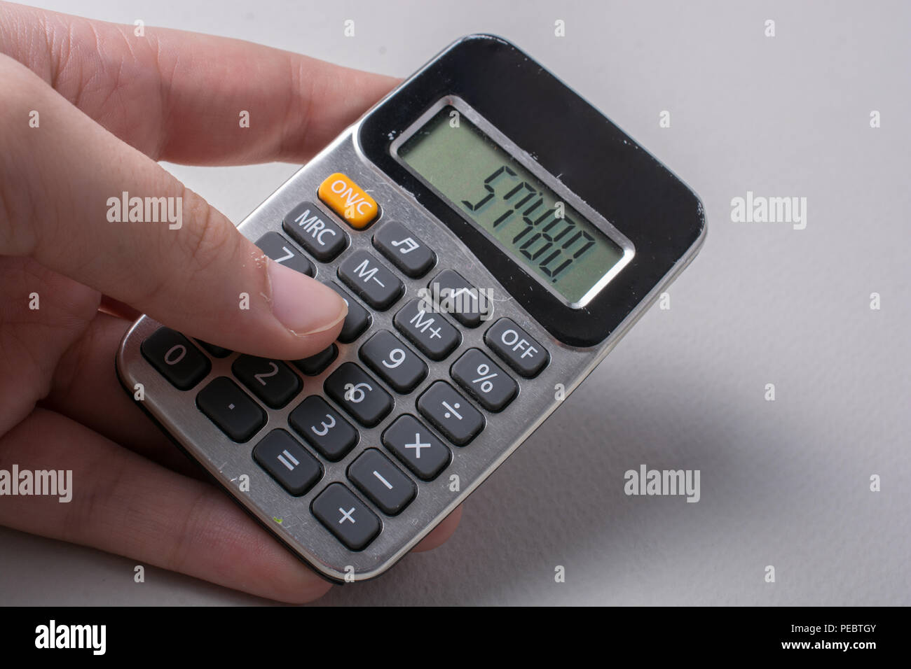 Hand holding a calculator in hand on white Stock Photo - Alamy