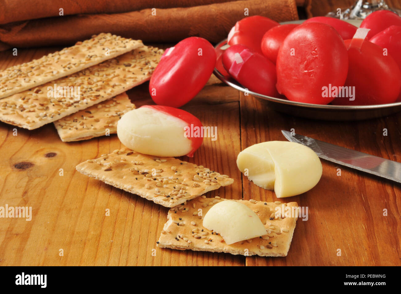 Mozzarella cheese in red wax wrappers with flatbread crackers Stock ...