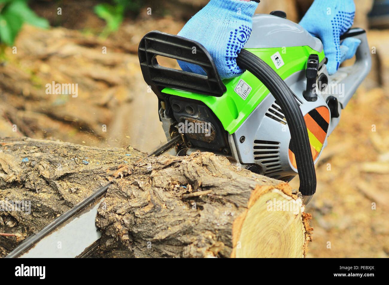 Man hands holding a chainsaw switched on Stock Photo - Alamy