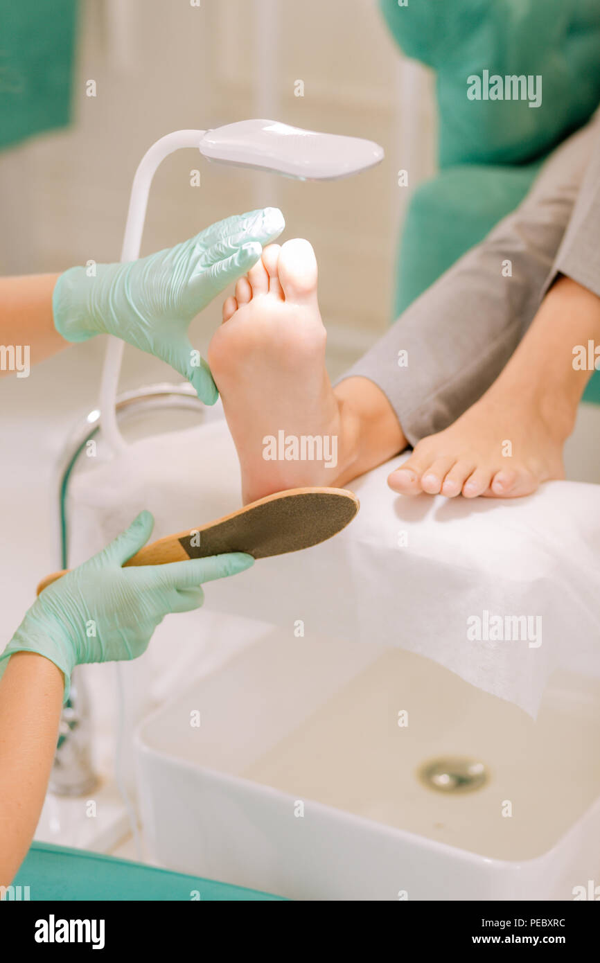 Chiropodist using white lamp while making pedicure for man Stock Photo ...