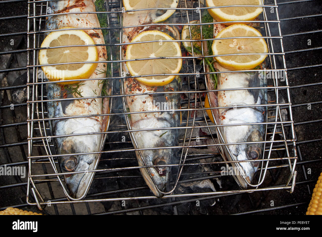 grilling fresh mackerel with lemon on the bbq in the uk Stock Photo - Alamy