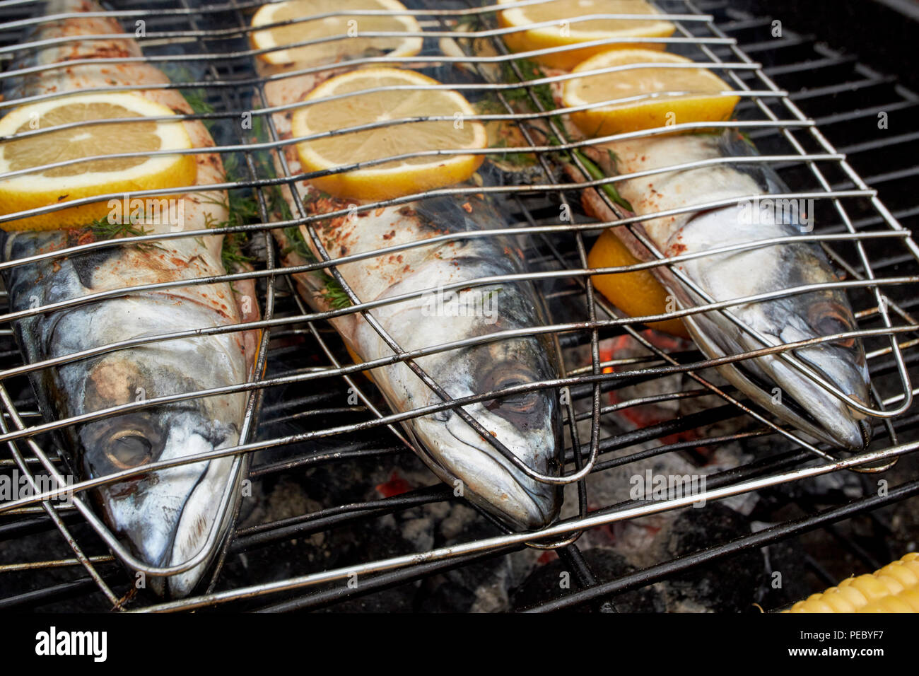 grilling fresh mackerel with lemon on the bbq in the uk Stock Photo - Alamy