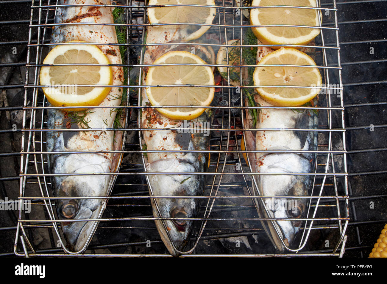 grilling fresh mackerel with lemon on the bbq in the uk Stock Photo - Alamy