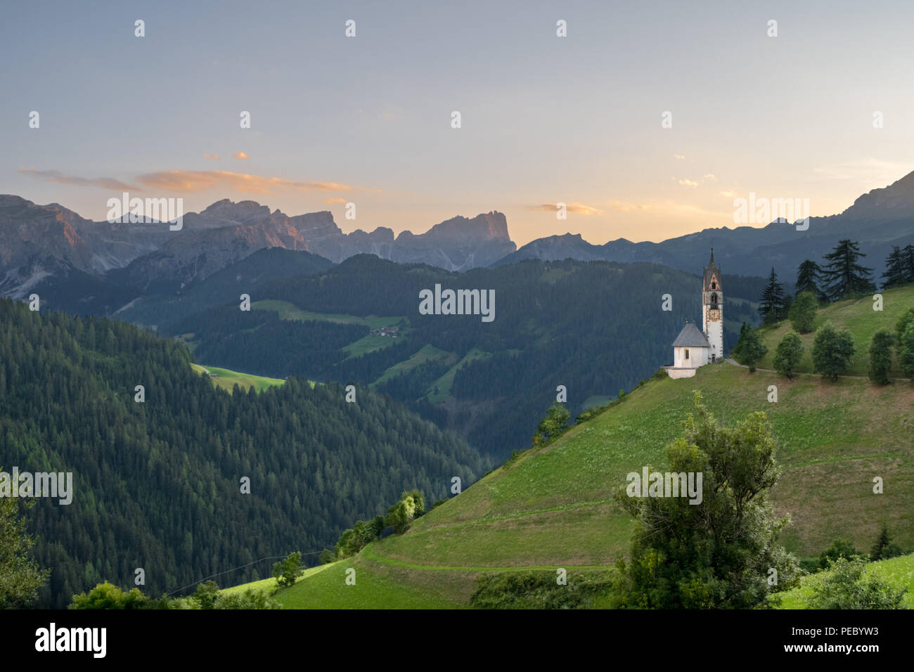 Church on a steep hillside with mountain peaks in the background in La ...