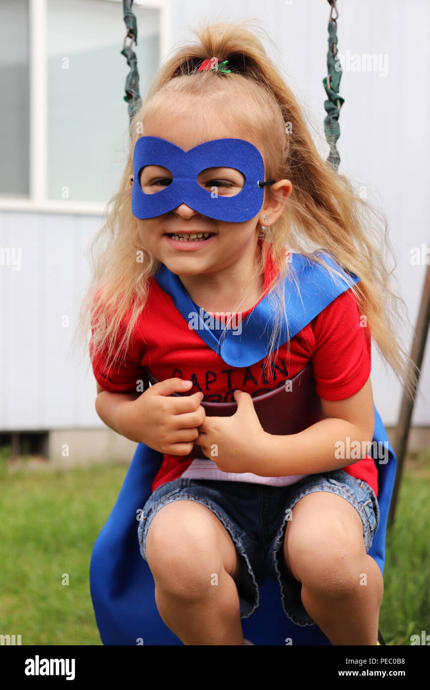 Toddler on swing playing Superhero Stock Photo - Alamy