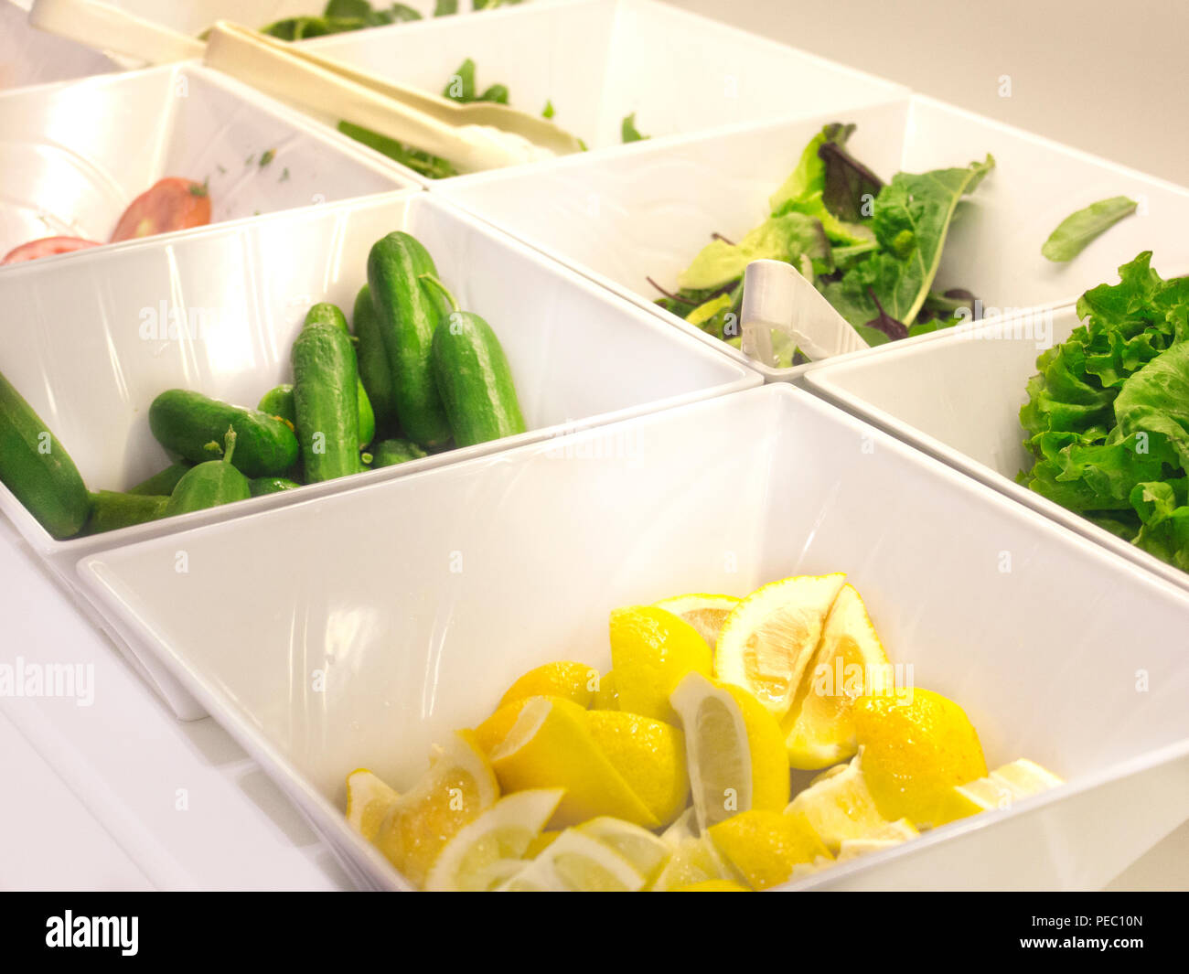 Open buffet at the hotel. Fresh cucumbers, sliced lemons and lettuce in ...
