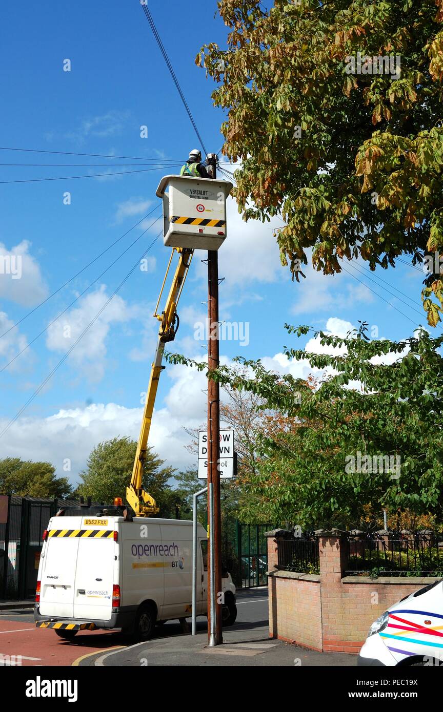 Telephone engineer working on telephone pole using van mounted lifting ...