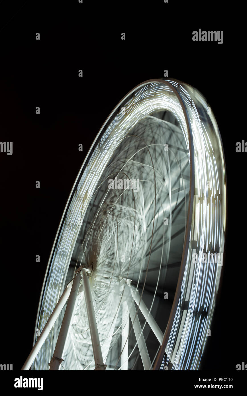selective focus of blurred observation wheel at night on black ...