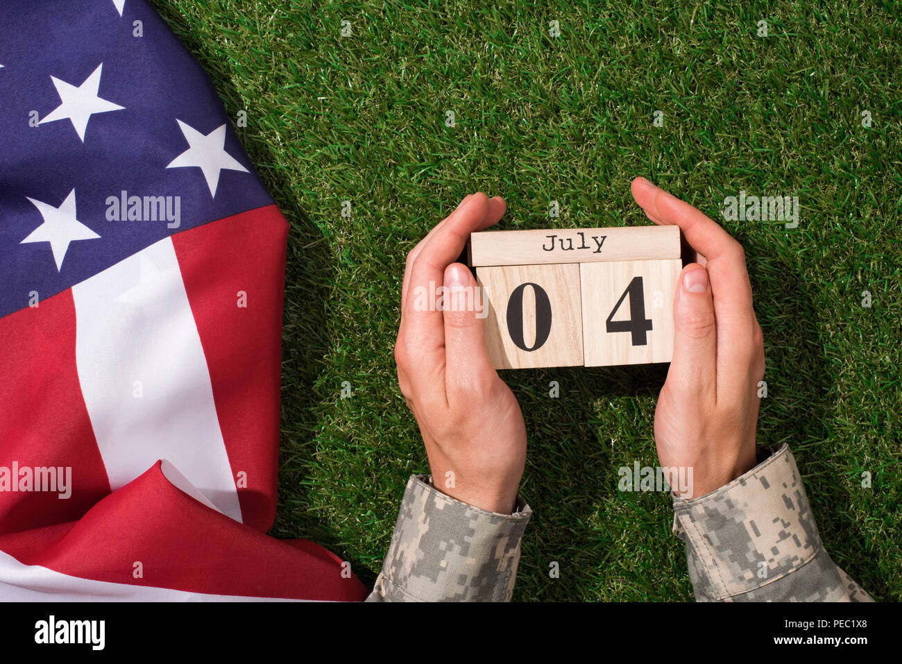 cropped shot of soldier in military uniform holding calendar with 4th ...