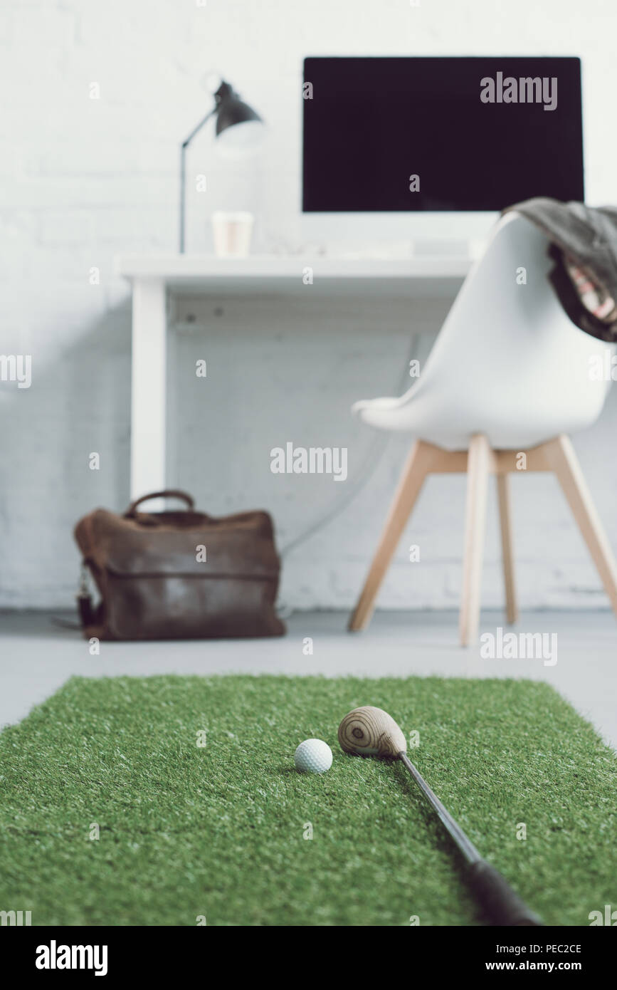 golf club and ball on green grass carpet in light modern office Stock ...