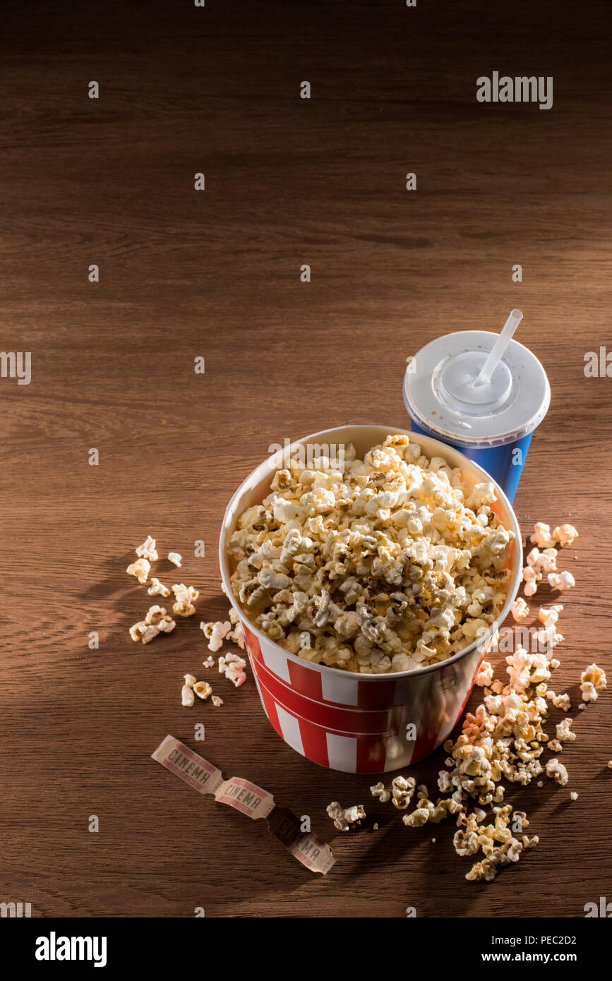 close up view of paper bucket with popcorn, soda drink and retro cinema ...