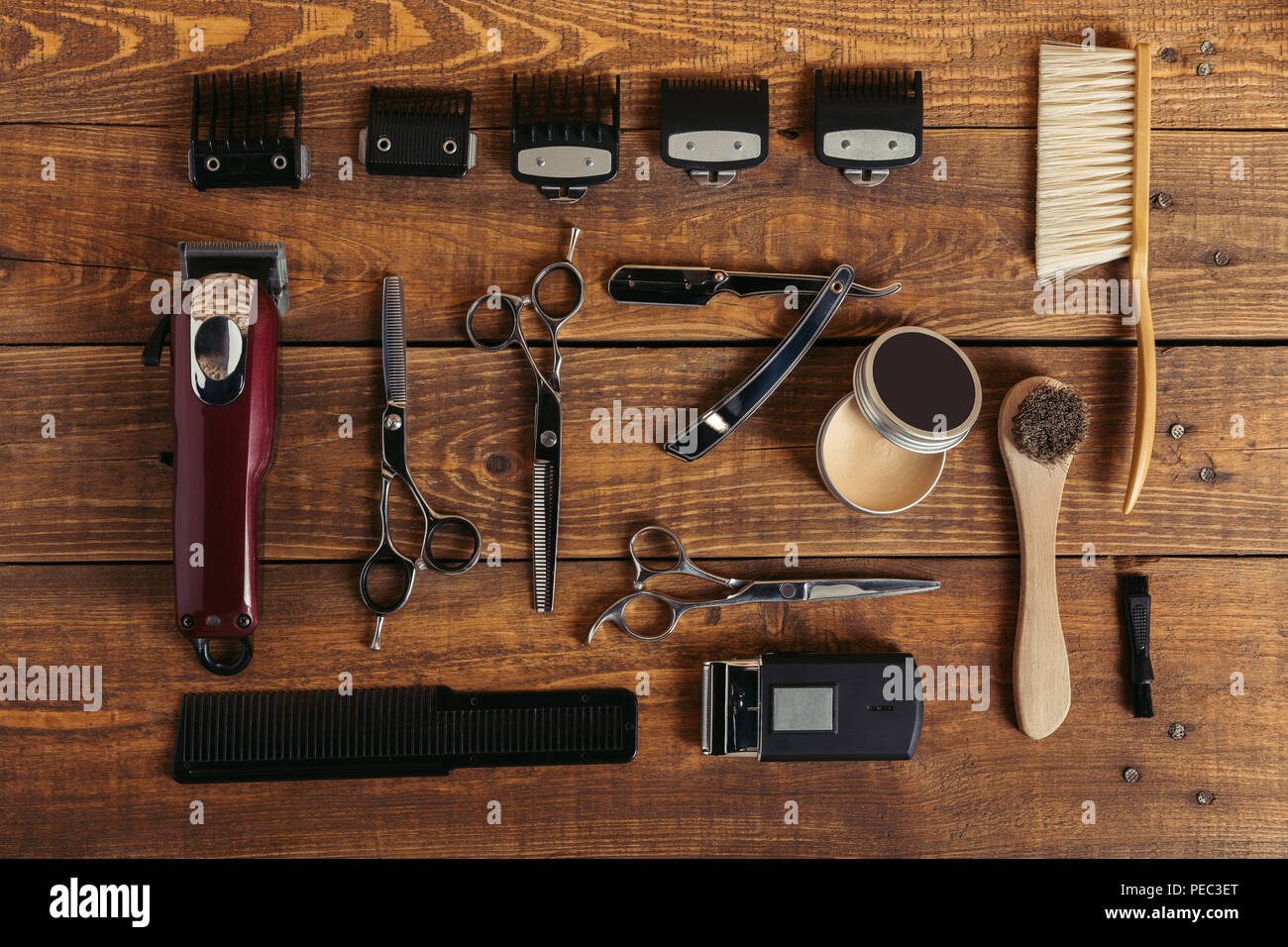 top view of various professional barber tools on wooden surface in hair ...