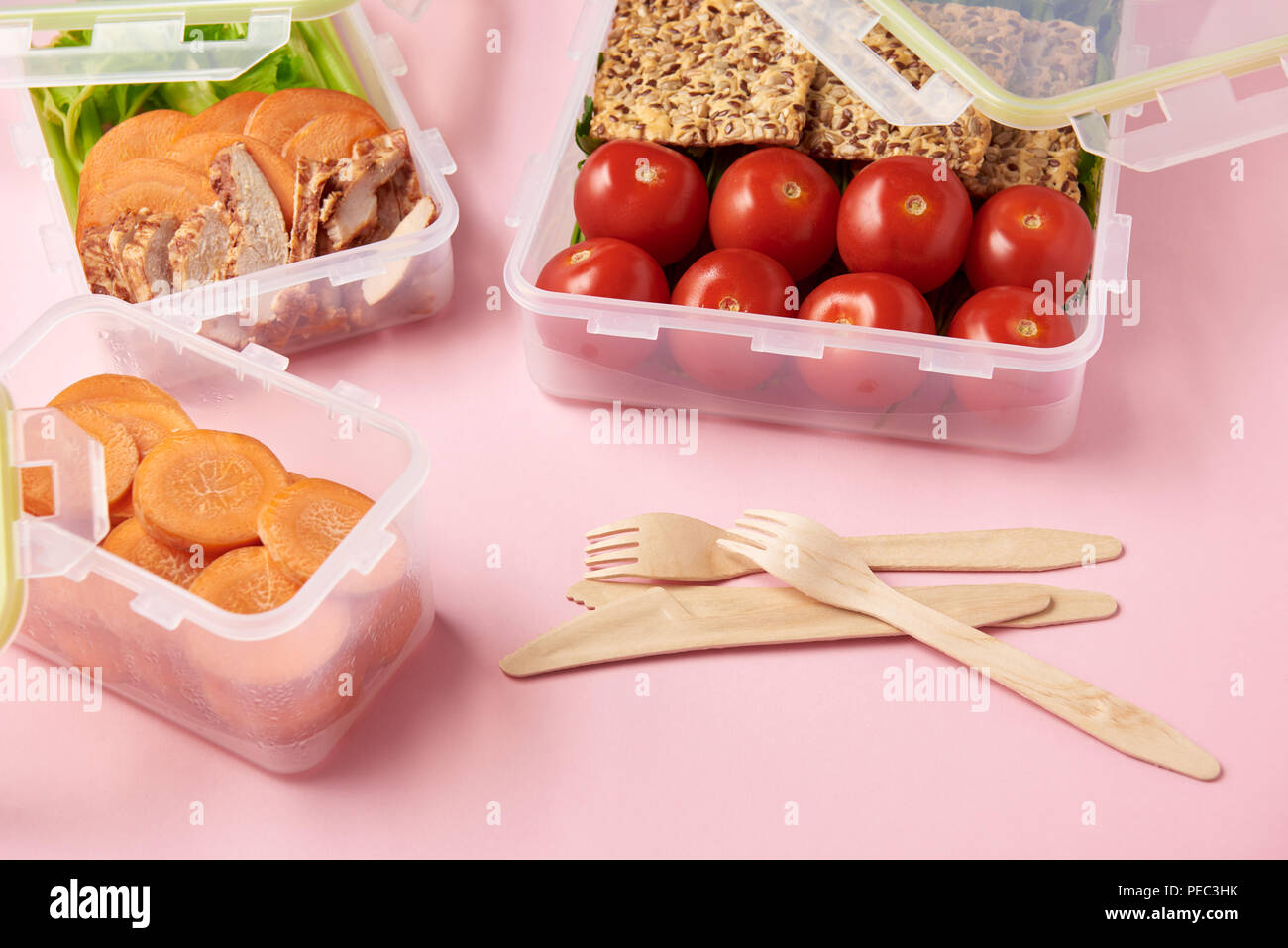 close up view of healthy food arranged in food containers and cutlery ...
