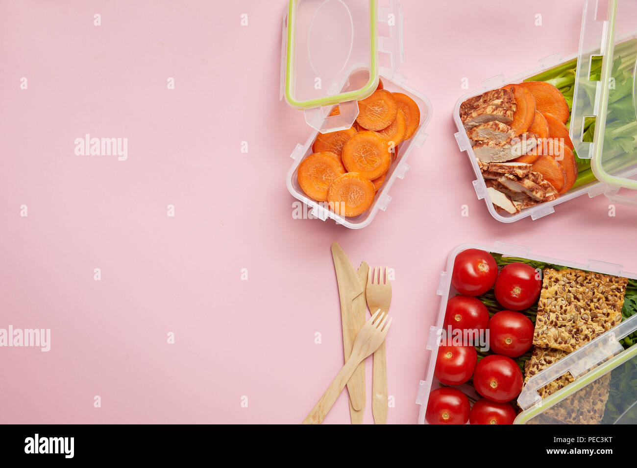 flat lay with healthy food arranged in food containers and cutlery ...