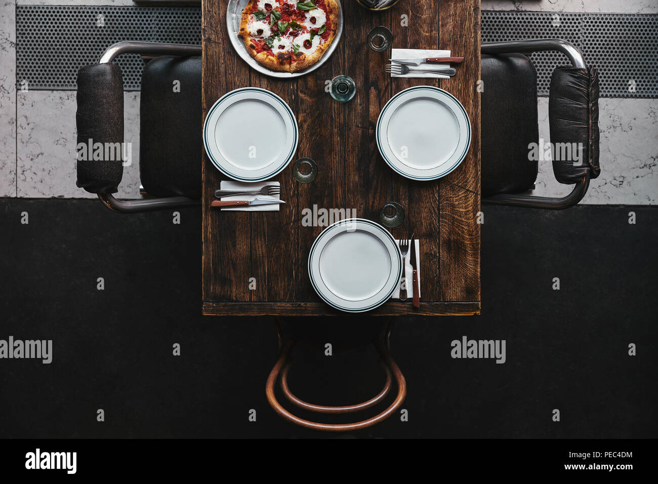 top view of pizza margherita on tray and table setting at restaurant ...
