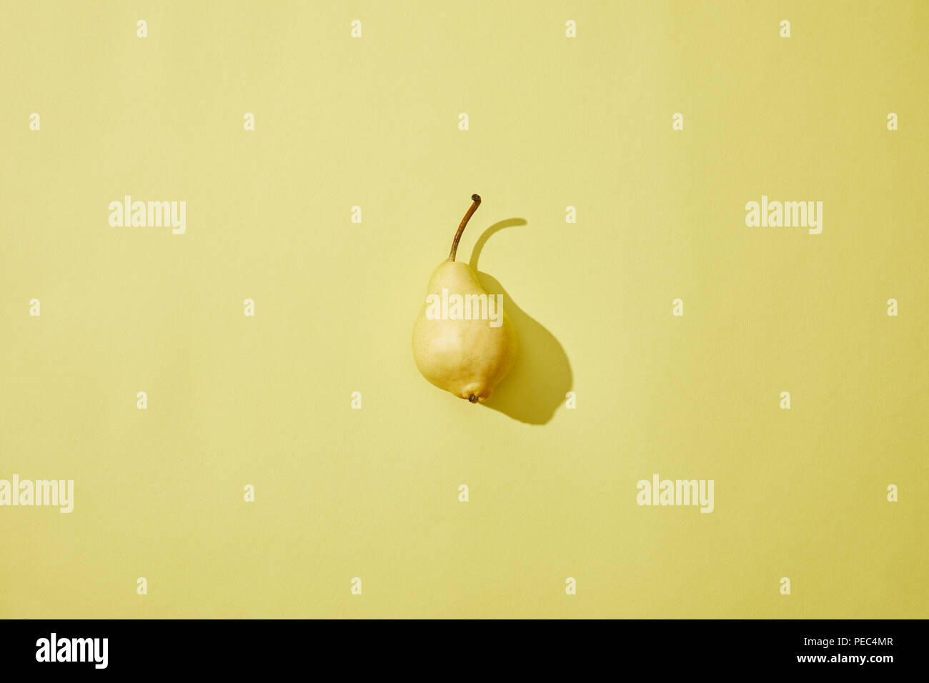 top view of single fresh ripe pear on yellow background Stock Photo - Alamy
