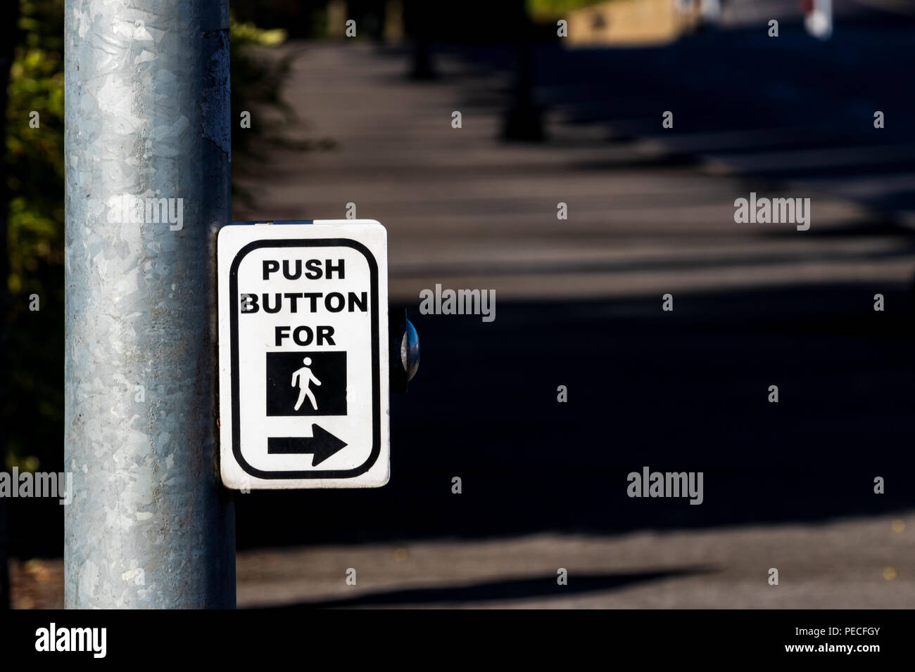 Crosswalk button mechanism on a steel post with a sidewalk Stock Photo ...