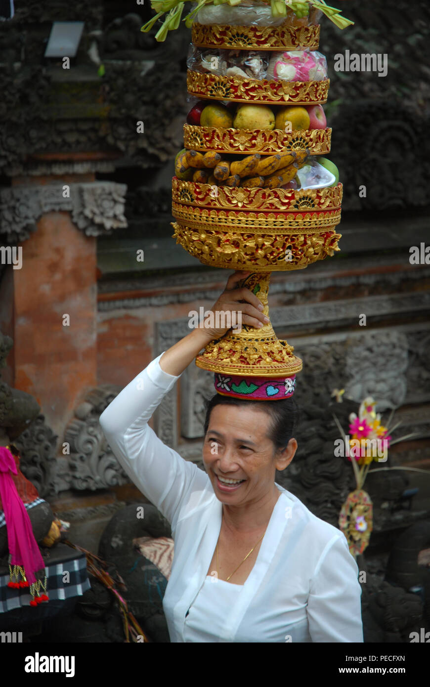 Lady carrying offerings on her head, Pura Dalem, Hindu temple in Ubud ...