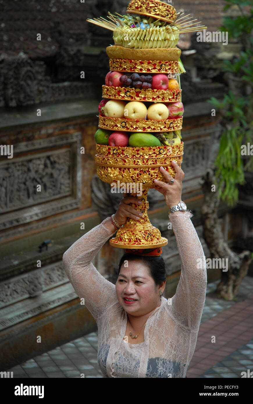 Lady carrying offerings on her head, Pura Dalem, Hindu temple in Ubud ...