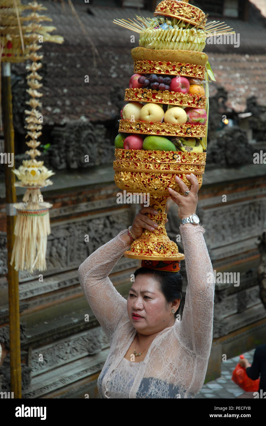 Lady carrying offerings on her head, Pura Dalem, Hindu temple in Ubud ...