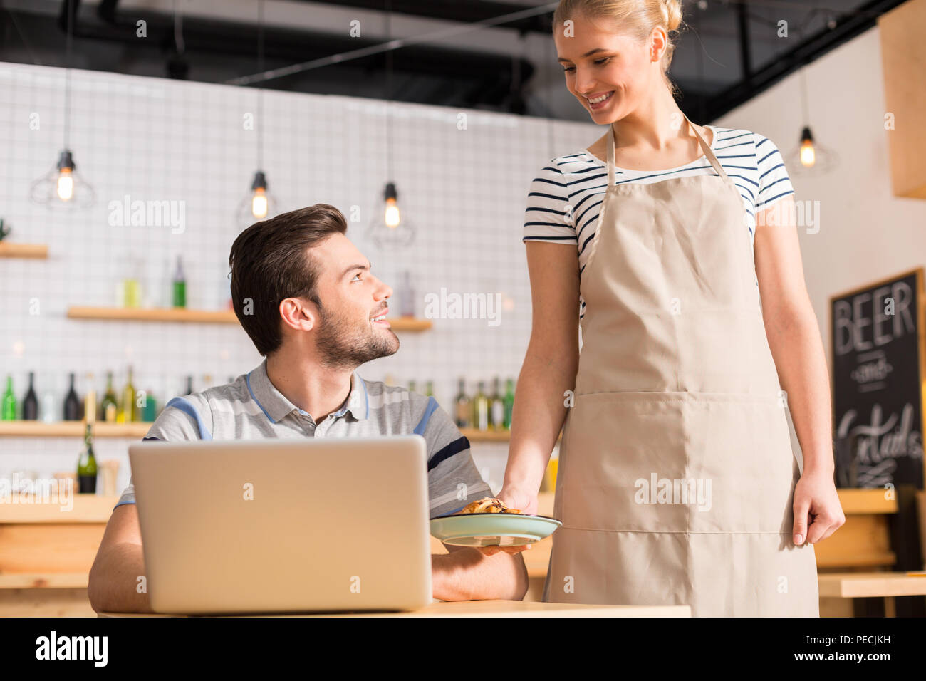Your dessert. Joyful nice positive waitress standing near the table and ...
