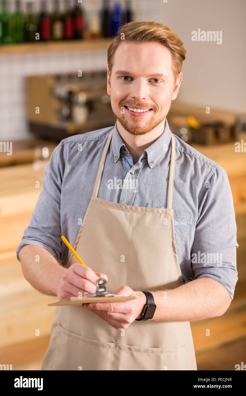 Professional service. Happy joyful nice man smiling and writing notes ...