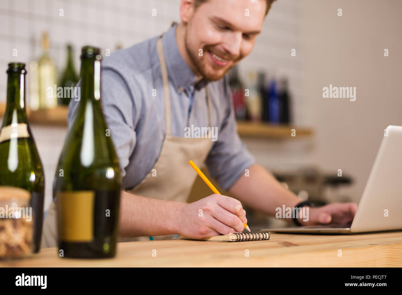 Making a list. Joyful nice pleasant man using a pencil and writing a ...