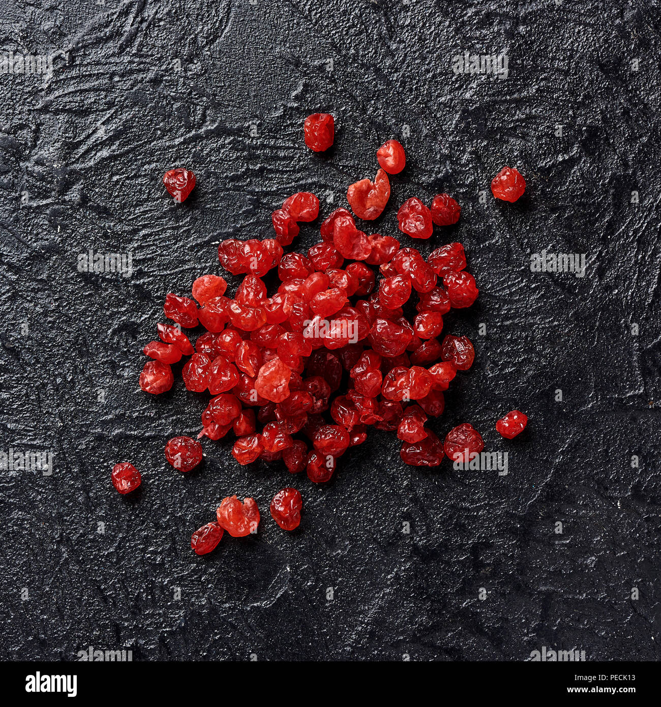 Dried red cherries on a black background Stock Photo - Alamy