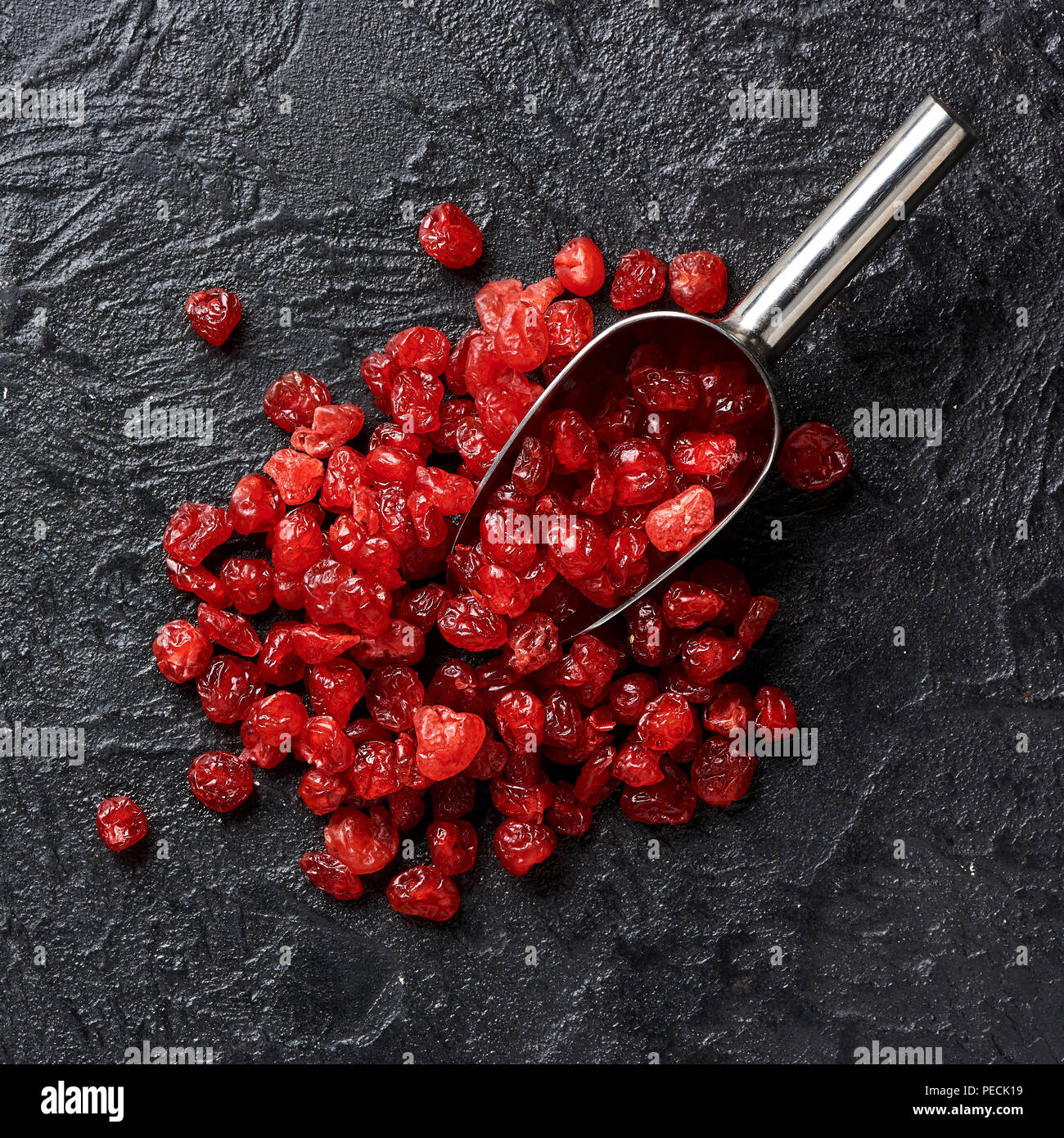 Dried red cherries on a black background with scoop Stock Photo - Alamy