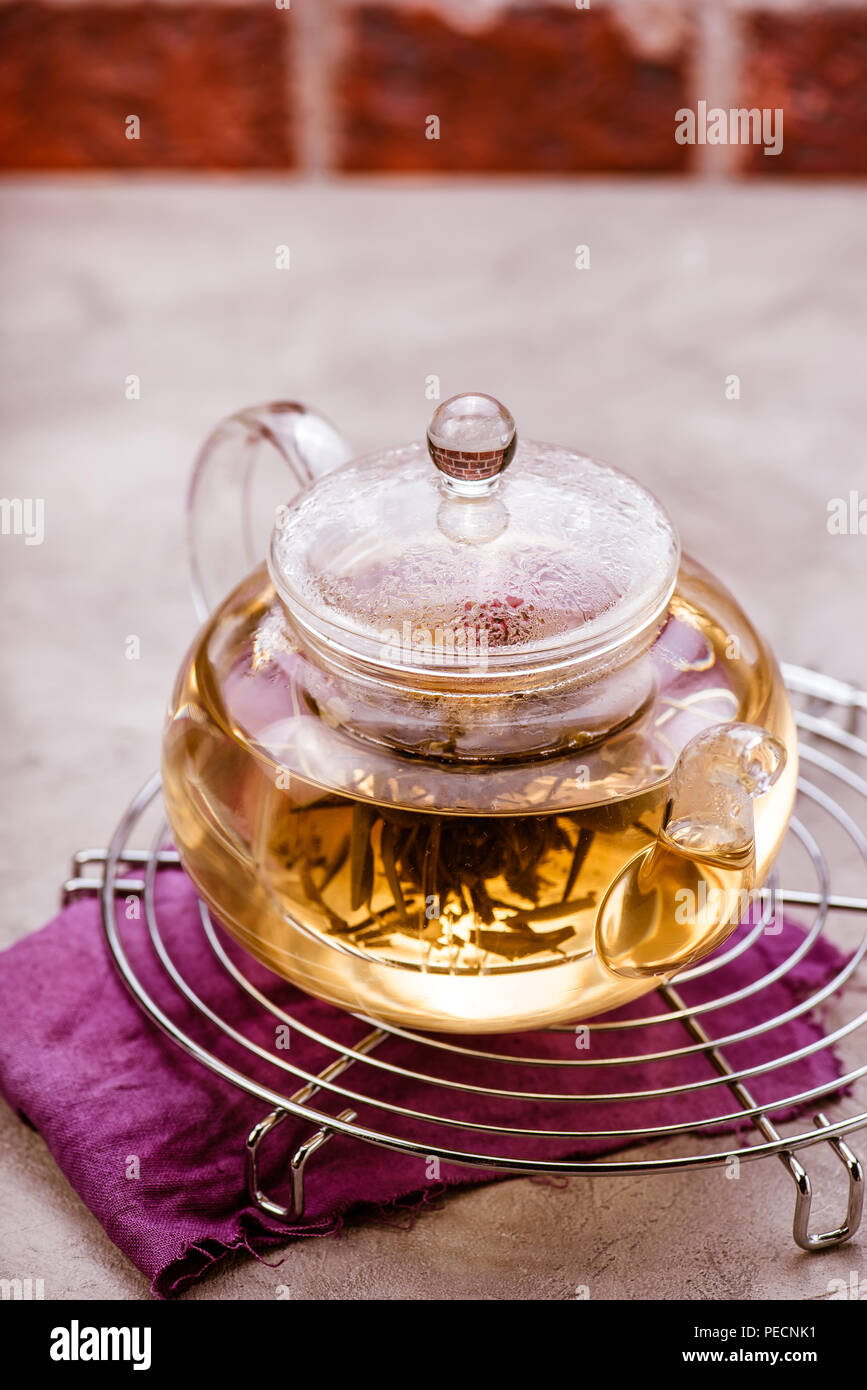 Glass teapot with tea on cooling rack. Front view Stock Photo - Alamy