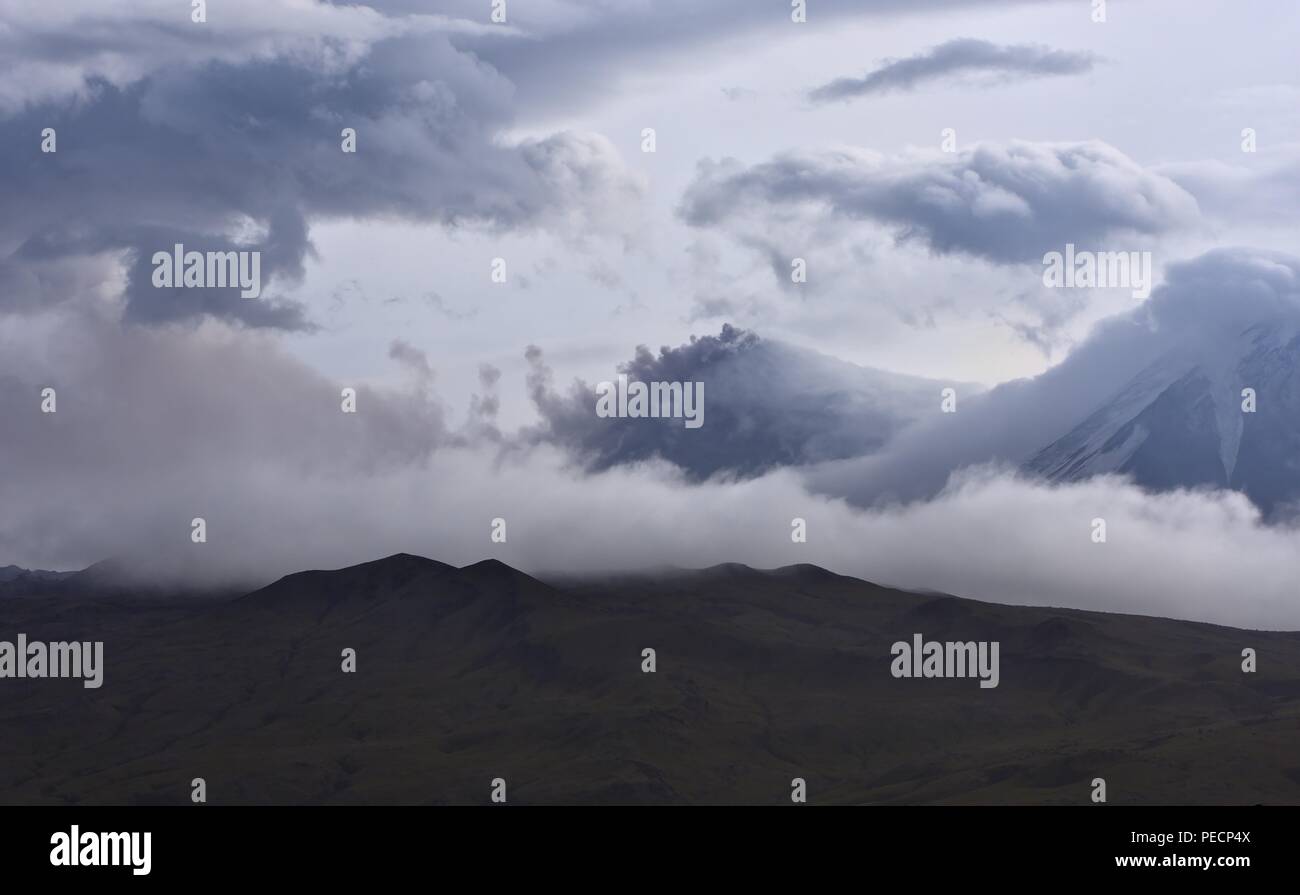 Kluchevskoy volcano slow eruption (smoke) with clouds around int Stock ...