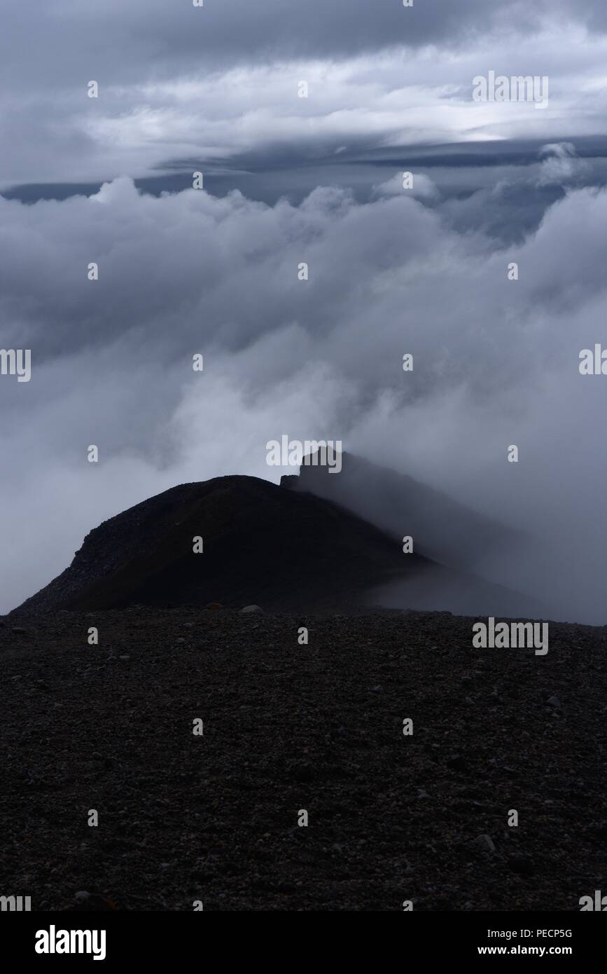 Mountain spur disappearing in dense clouds Stock Photo - Alamy