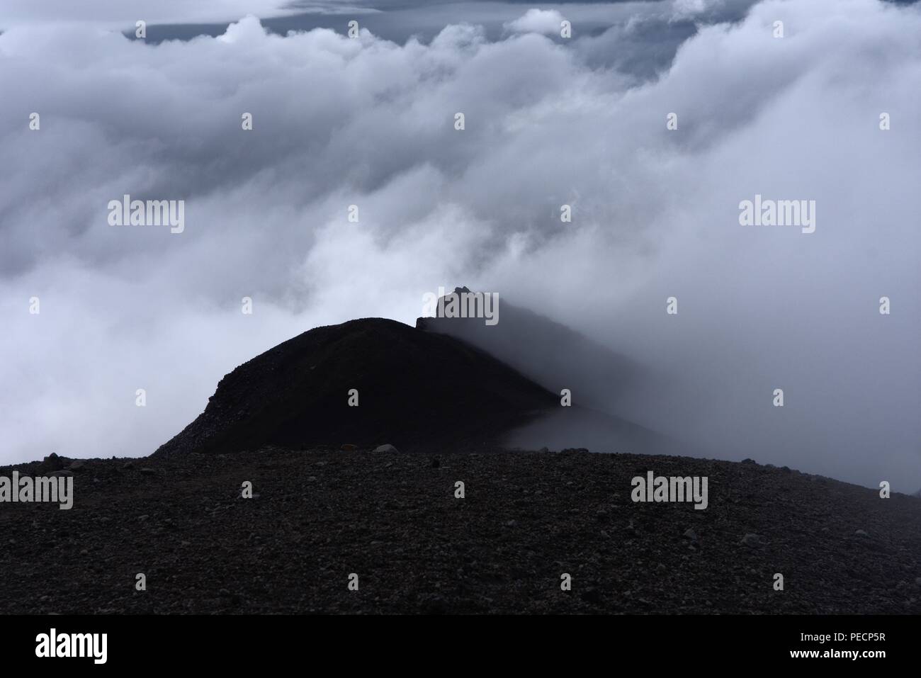 Mountain spur disappearing in dense clouds Stock Photo - Alamy