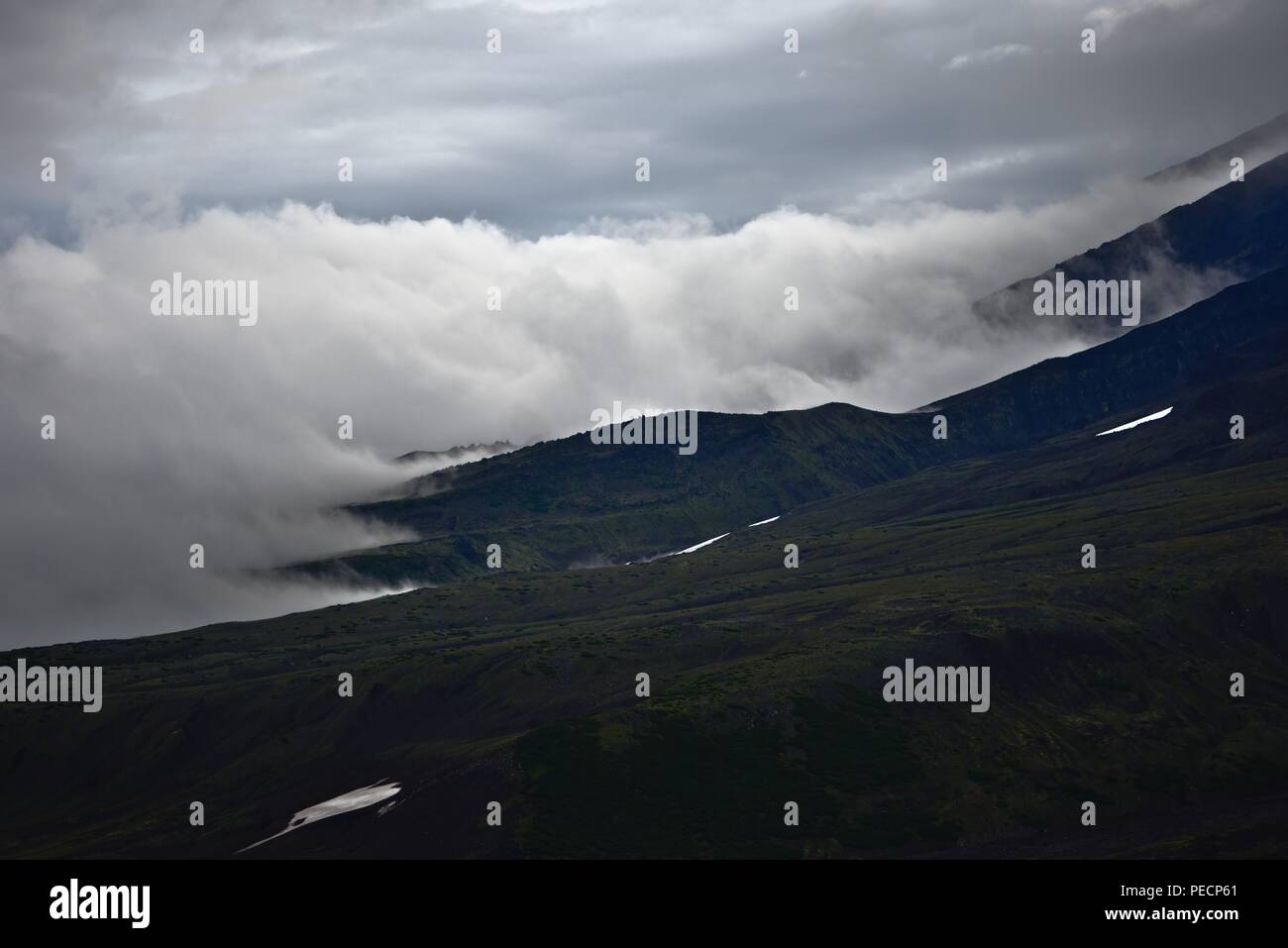 Mountain spur disappearing in dense clouds Stock Photo - Alamy