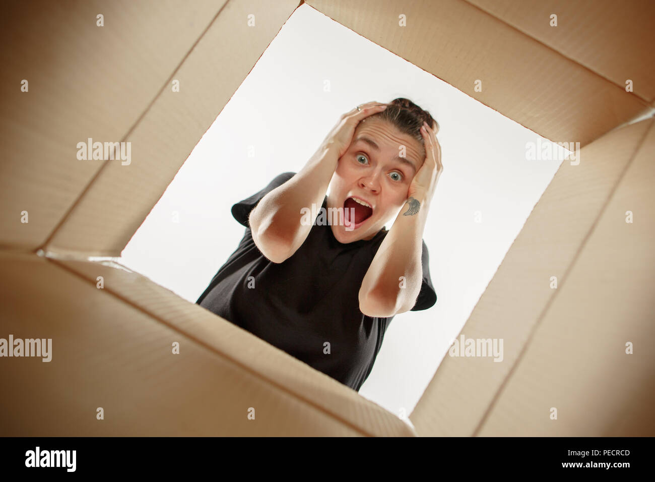 The surprised woman opening box and looking inside. The package ...