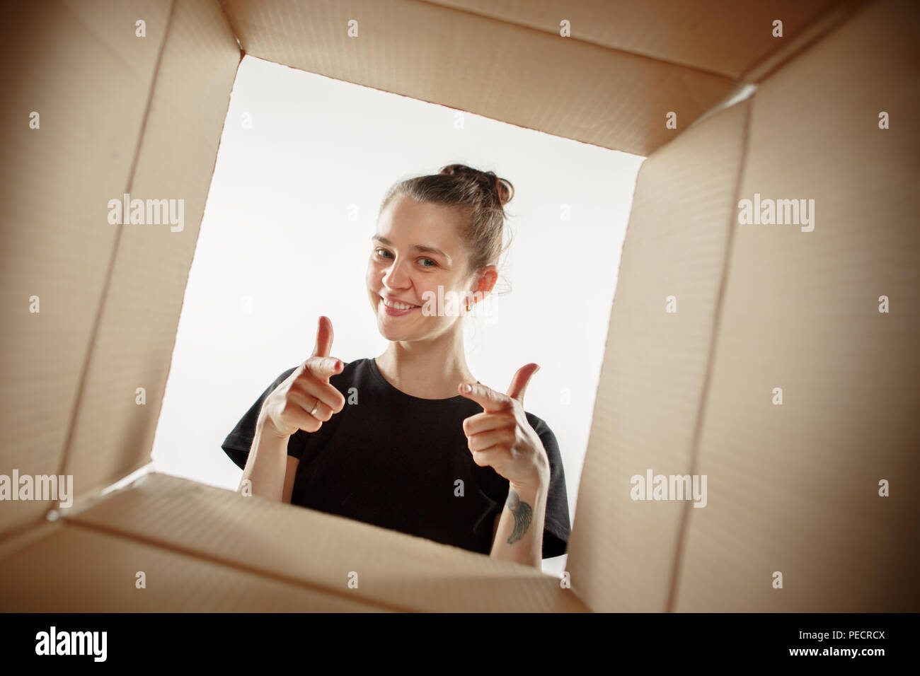 The surprised woman opening box and looking inside. The package ...