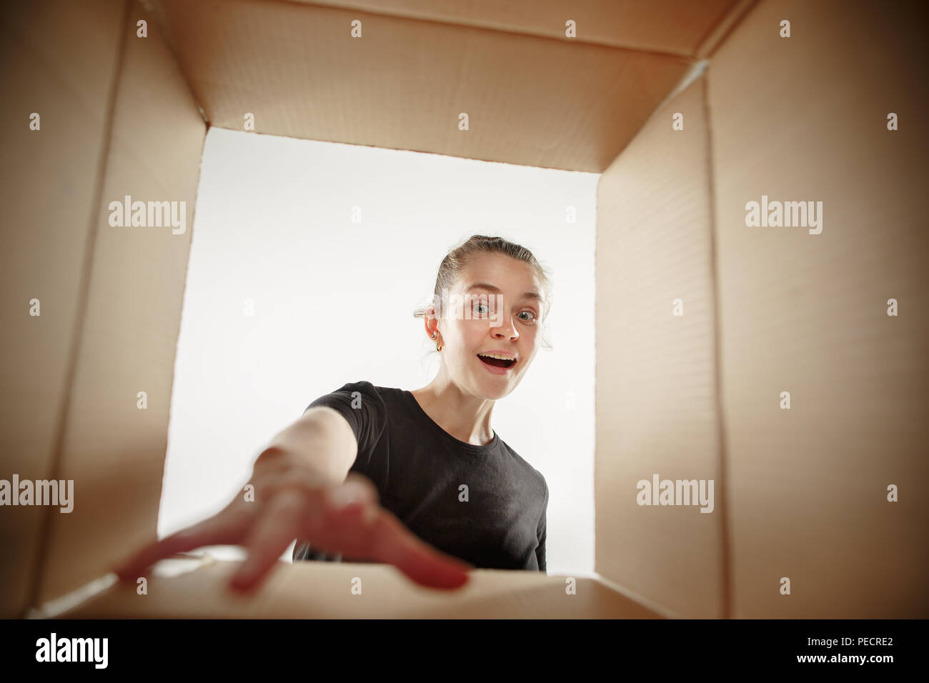 The surprised woman opening box and looking inside. The package ...
