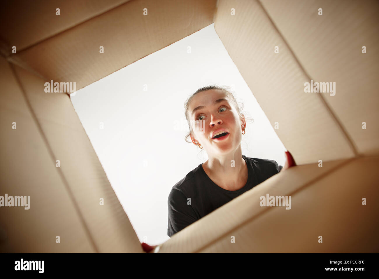 The surprised woman opening box and looking inside. The package ...