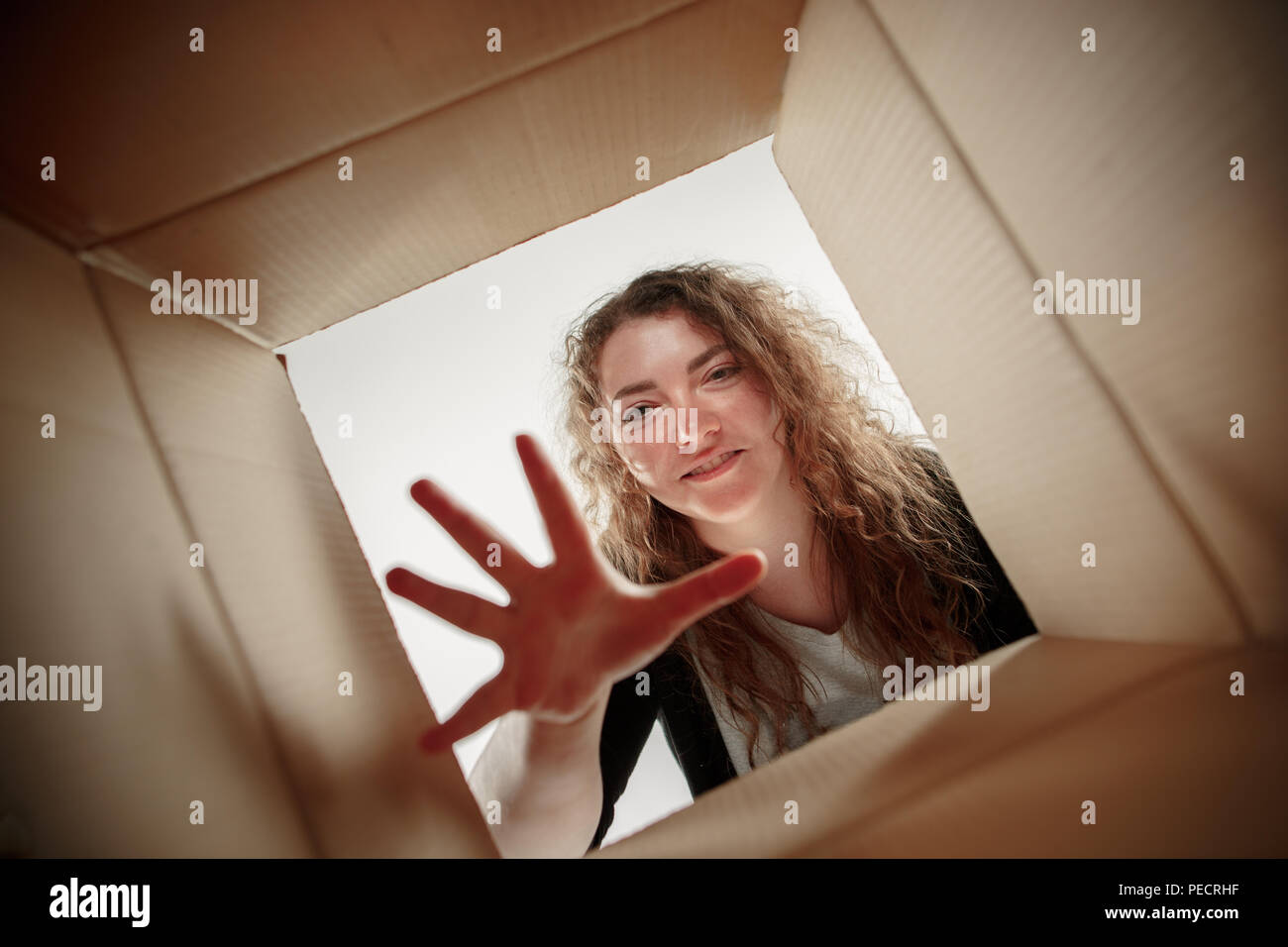 The surprised woman opening box and looking inside. The package ...