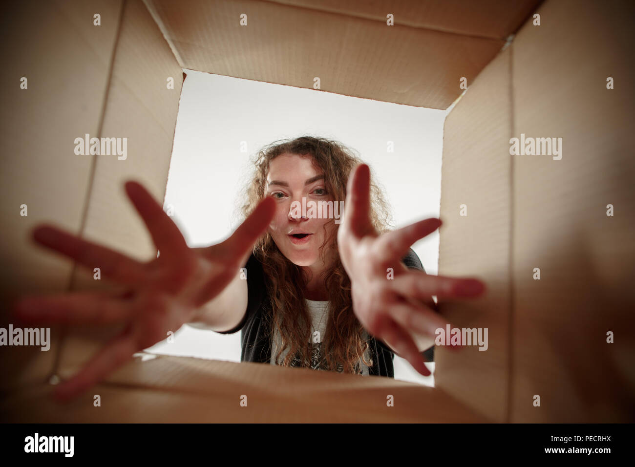 The surprised woman opening box and looking inside. The package ...