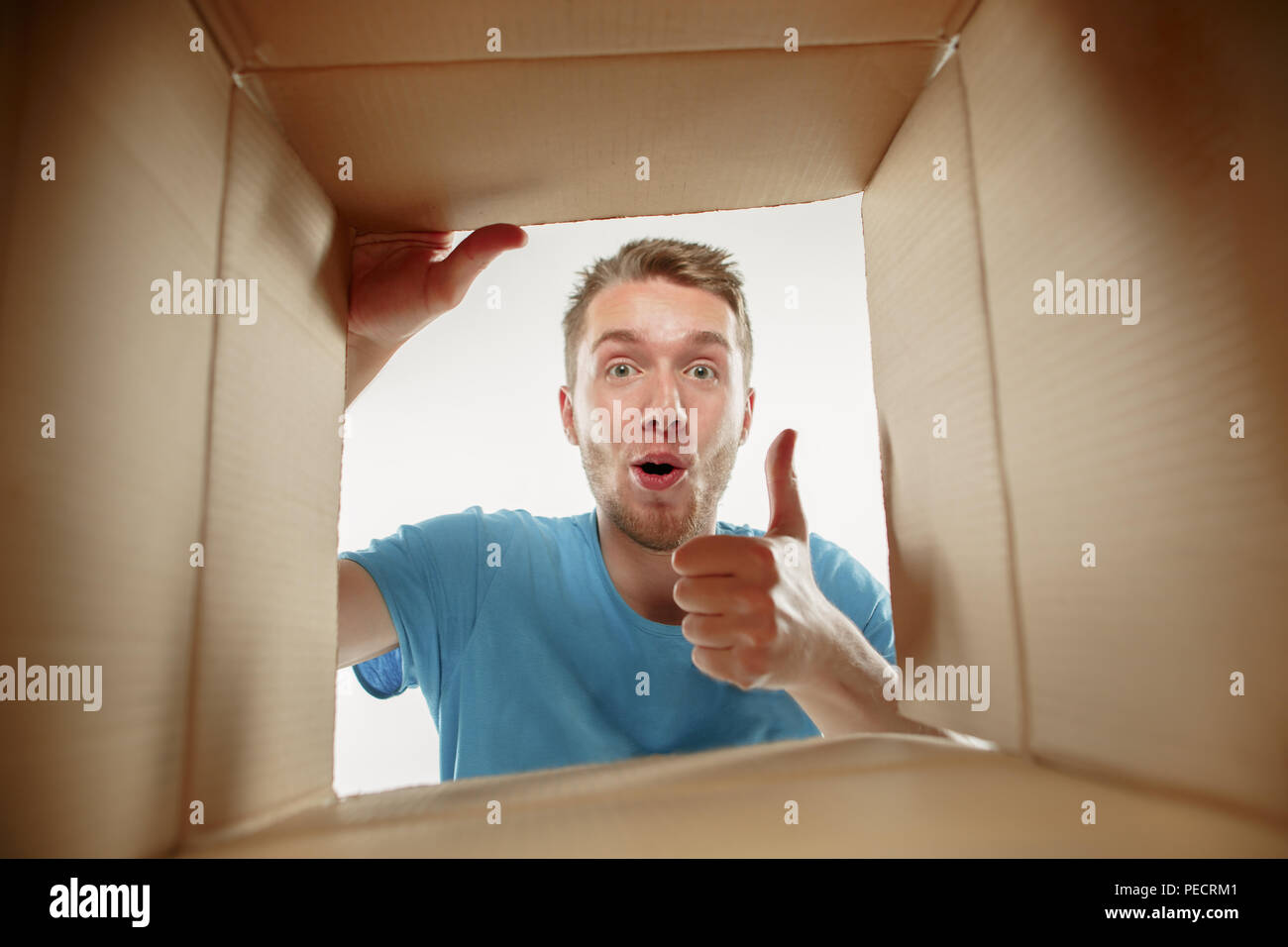 Man smiling, opening box and looking inside. The package, delivery ...